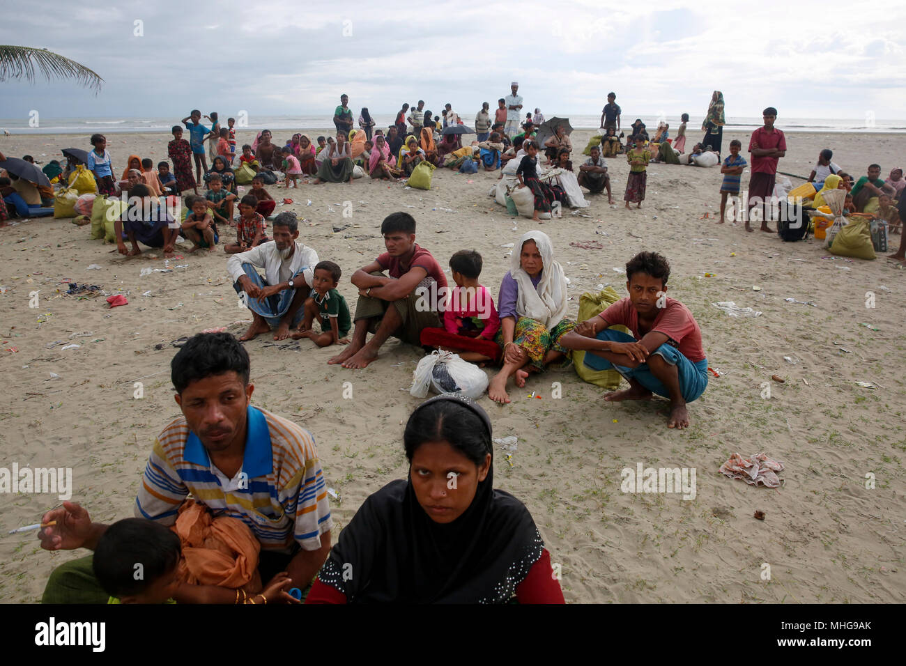 Rohingya refugees wait on the shore at Saha Porir Dwip after crossing ...