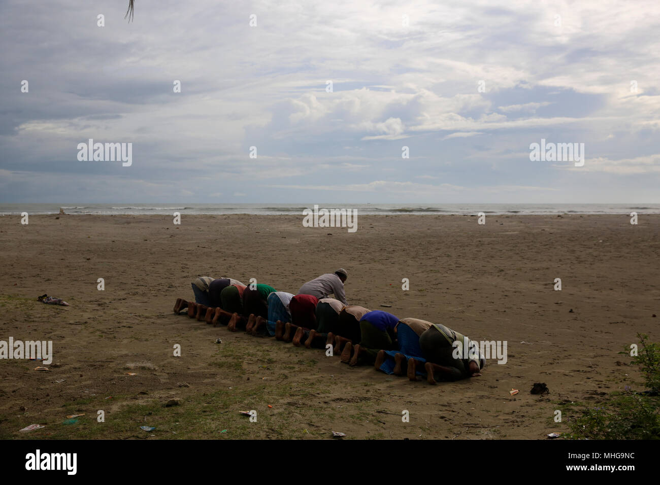 Rohingya refugees offer prayers on the shore after crossing the ...