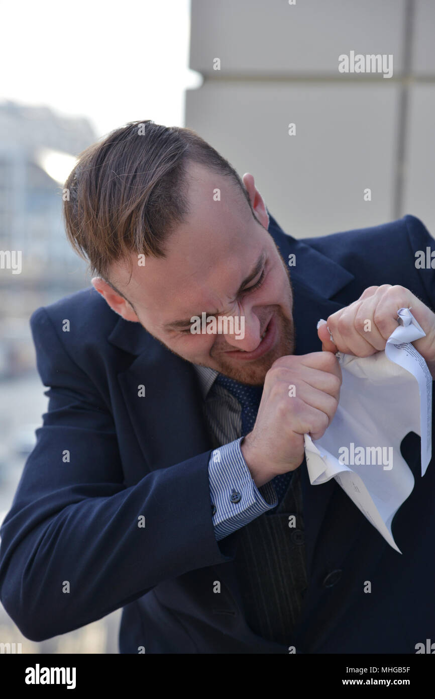 businessman emotionally tear and eat paper documents Stock Photo - Alamy