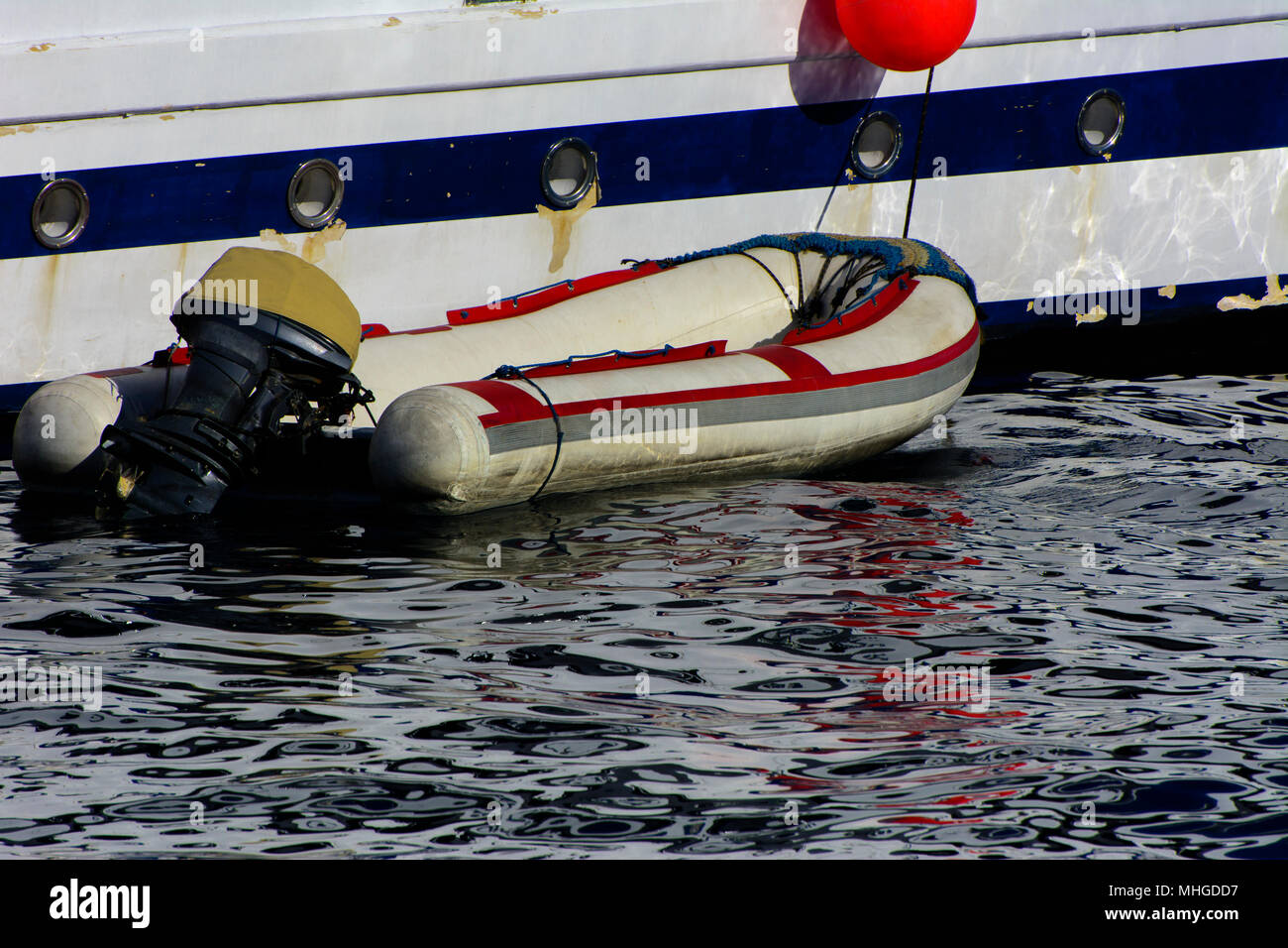 The old inflatable rubber boat is tied to the struggle of the ship in ...
