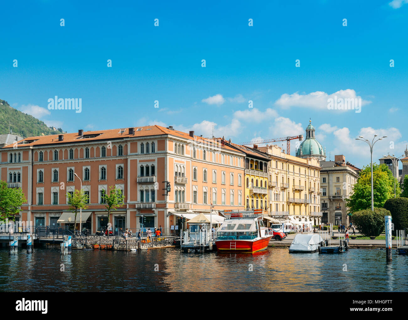 View of the city of Como, including boats on the marina and traditional ...