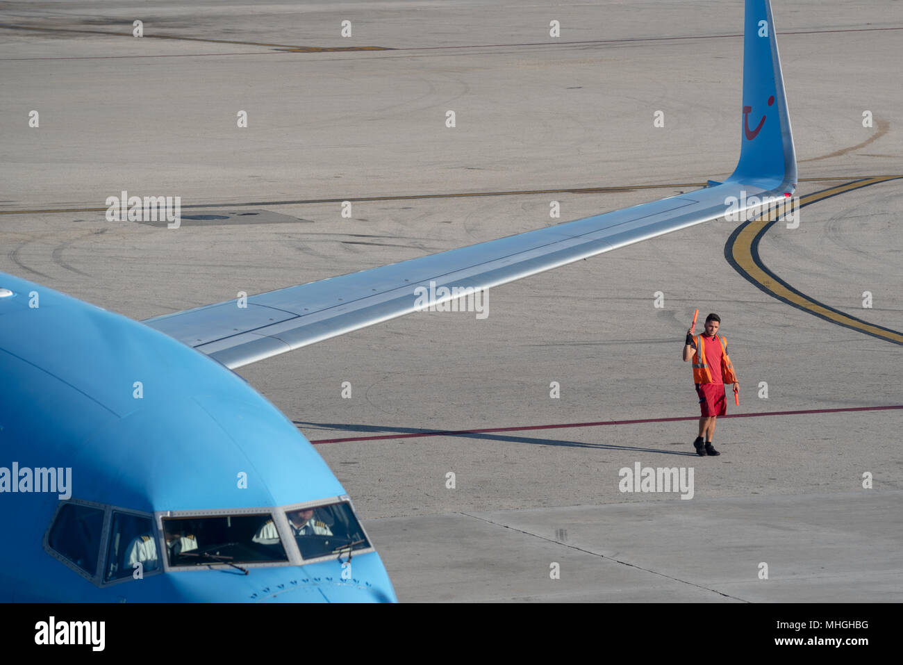 Wing walker directing a jet pushing back at Miami International Airport ...
