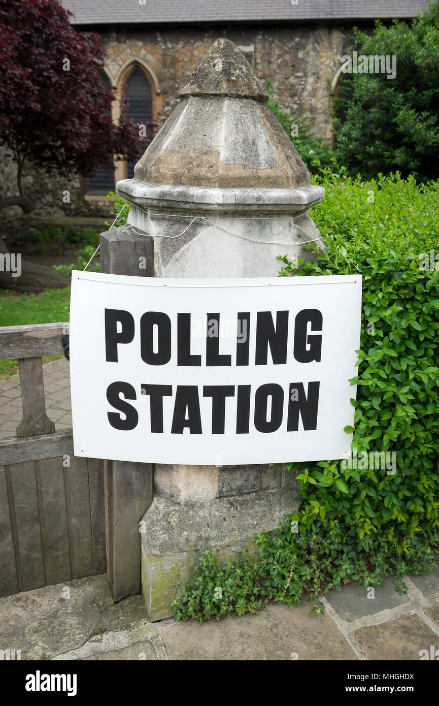 British election polling station sign hanging on post next to a gate ...