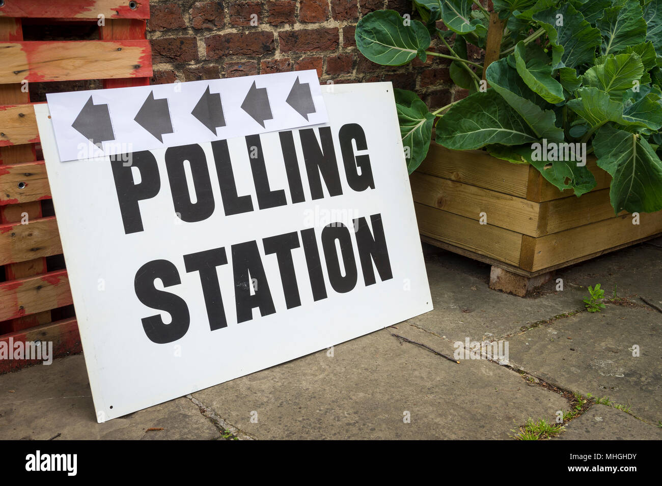 British election polling station sign propped up in an urban garden in ...