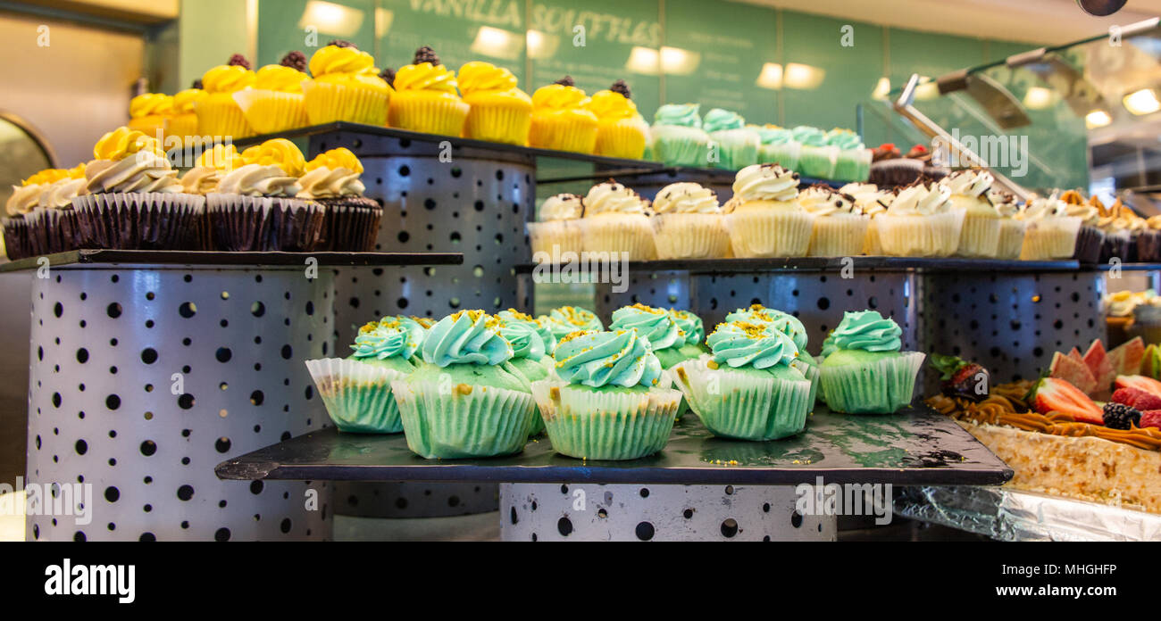 Frosted Green and Yellow Cupcakes in Bakery Case Stock Photo - Alamy