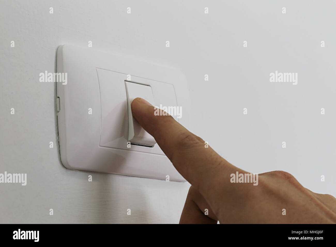 fingers are turning off light switch in the house,concept for energy ...