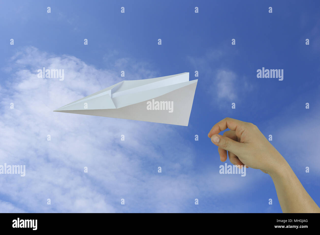Hands of businessman throwing a paper plane on blue sky background and ...