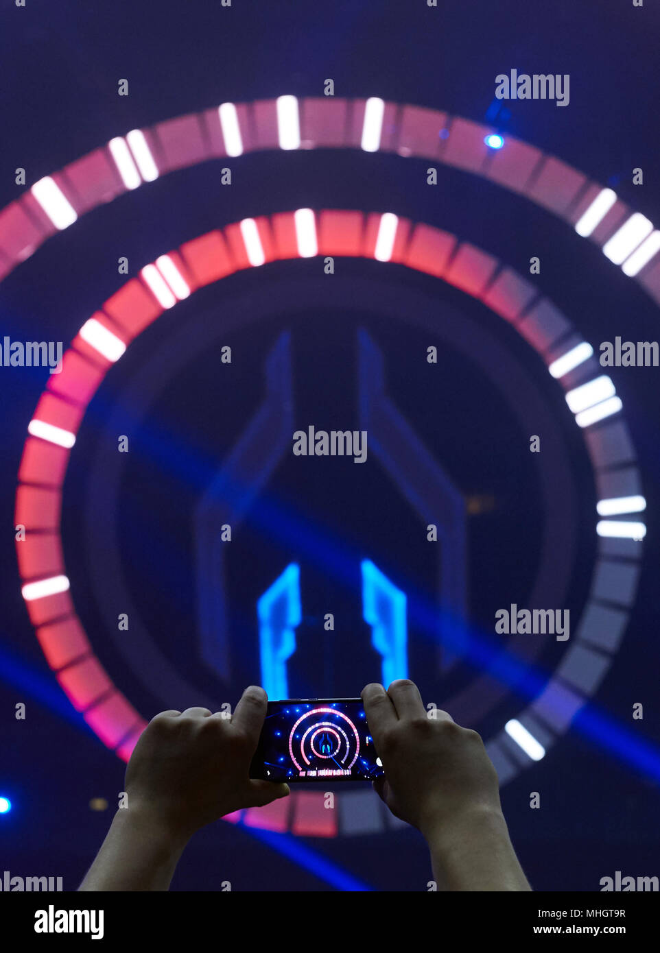 30 April 2018, Germany, Dortmund: A techno fan filming the light show ...