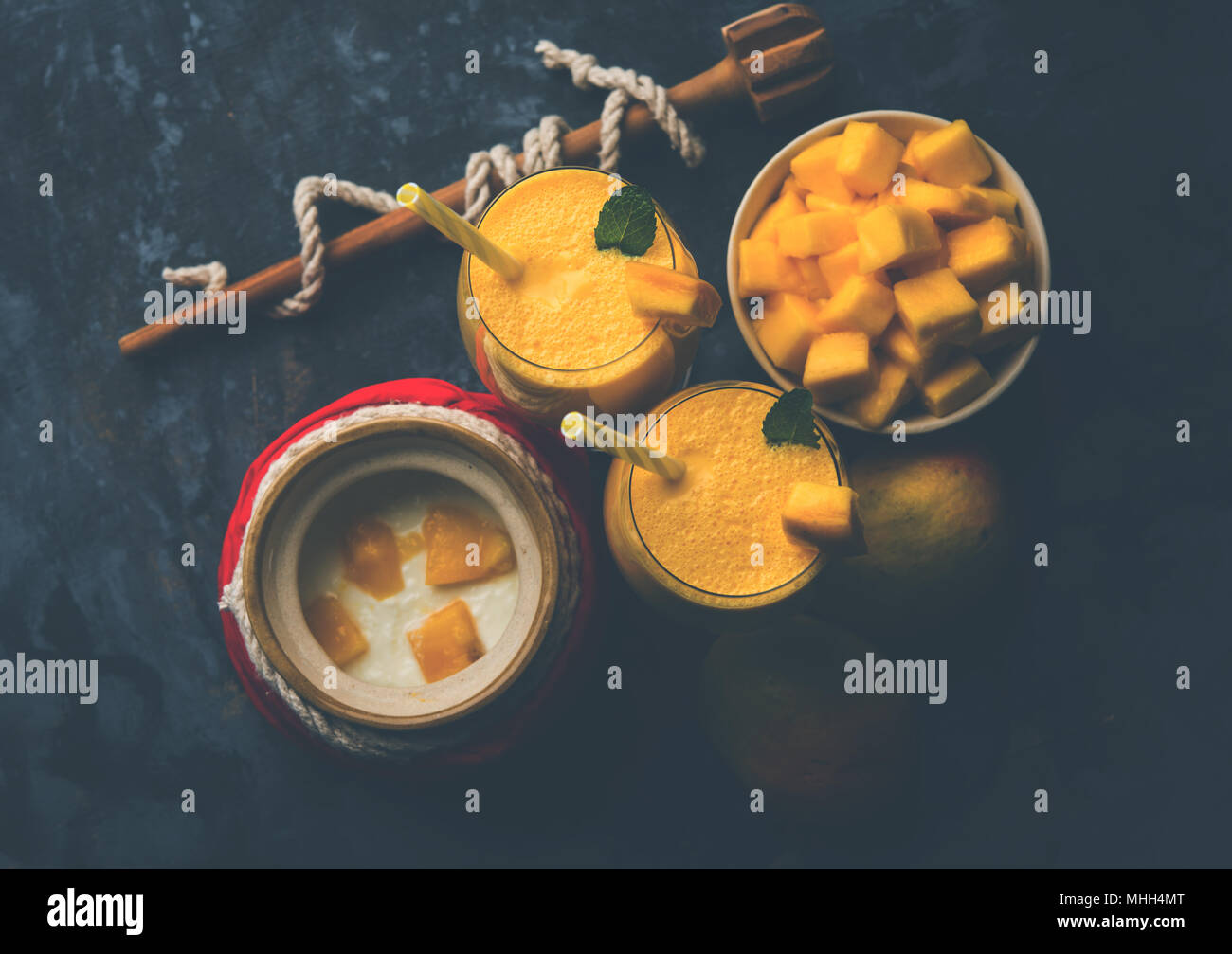 Mango Lassi or smoothie in big glass or small bottles with curd, cut ...