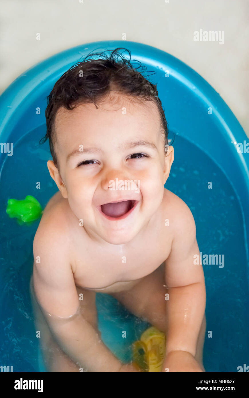 cute toddler taking a bath/ Caucasian toddler with wet dark hair in a ...