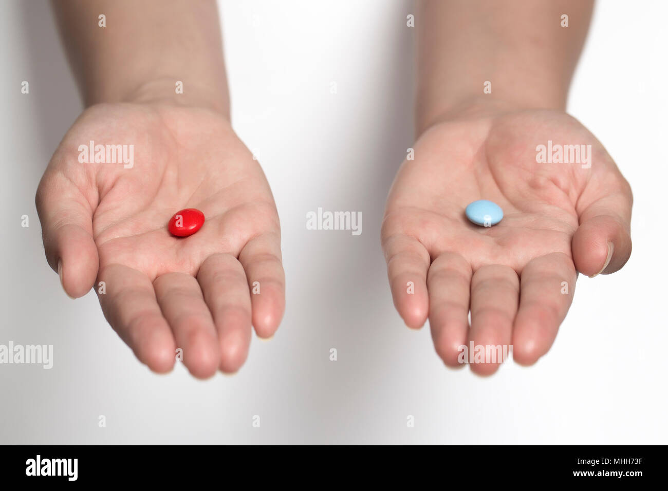 two tablets red and blue to choose from on the palms Stock Photo - Alamy