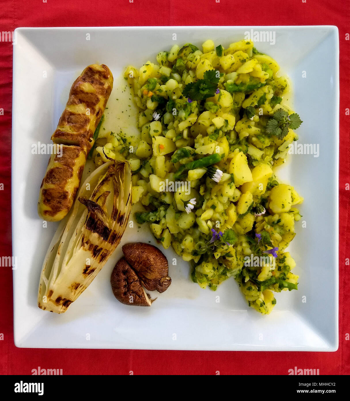 Grilled sausage, mushroom and chicory, served with potato salad with ...