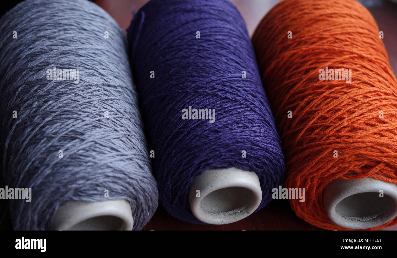 Three cones of bright wool yarn for machine knitting Stock Photo - Alamy