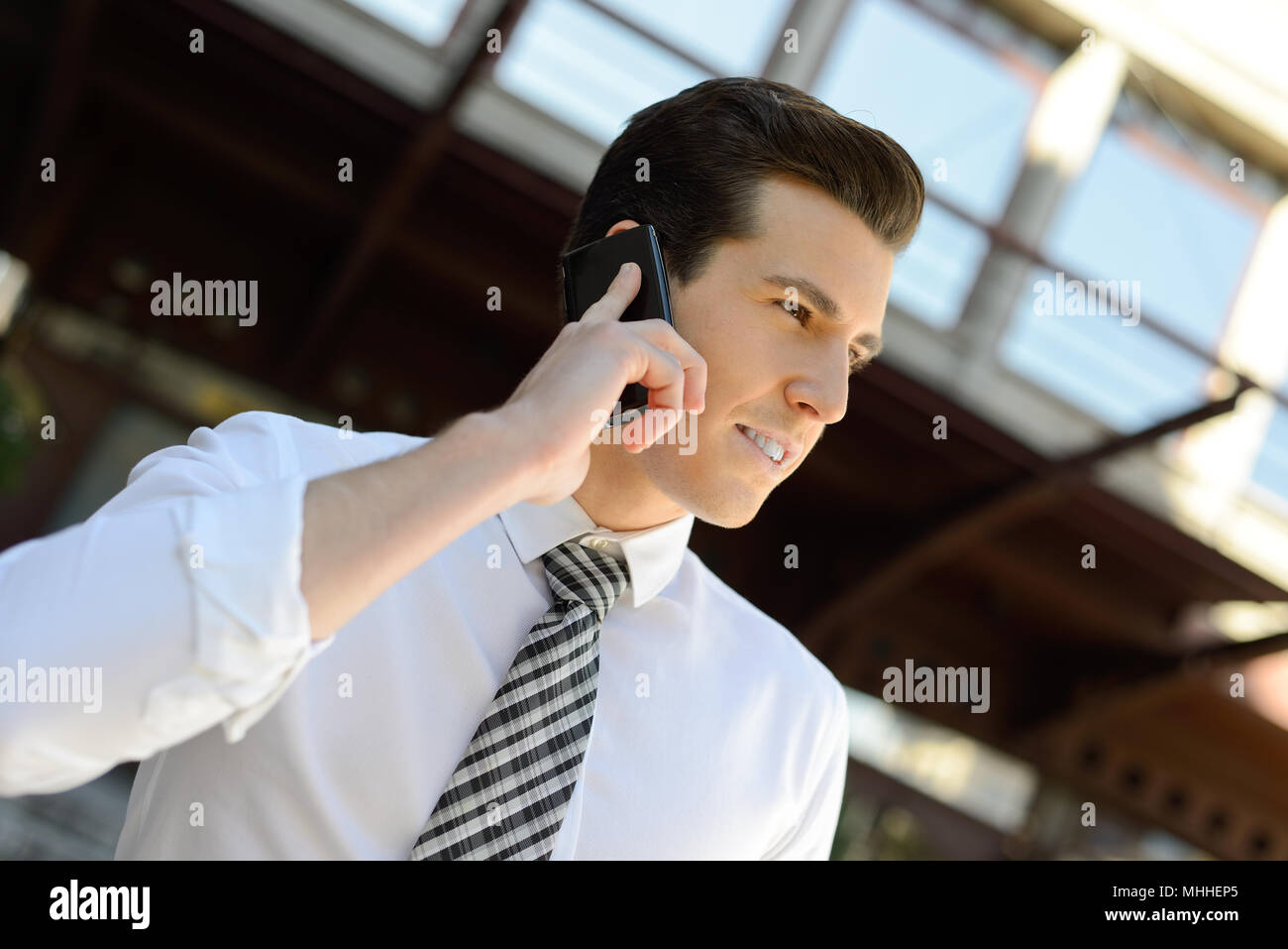 Portrait of an attractive businessman making a call using a smart phone ...