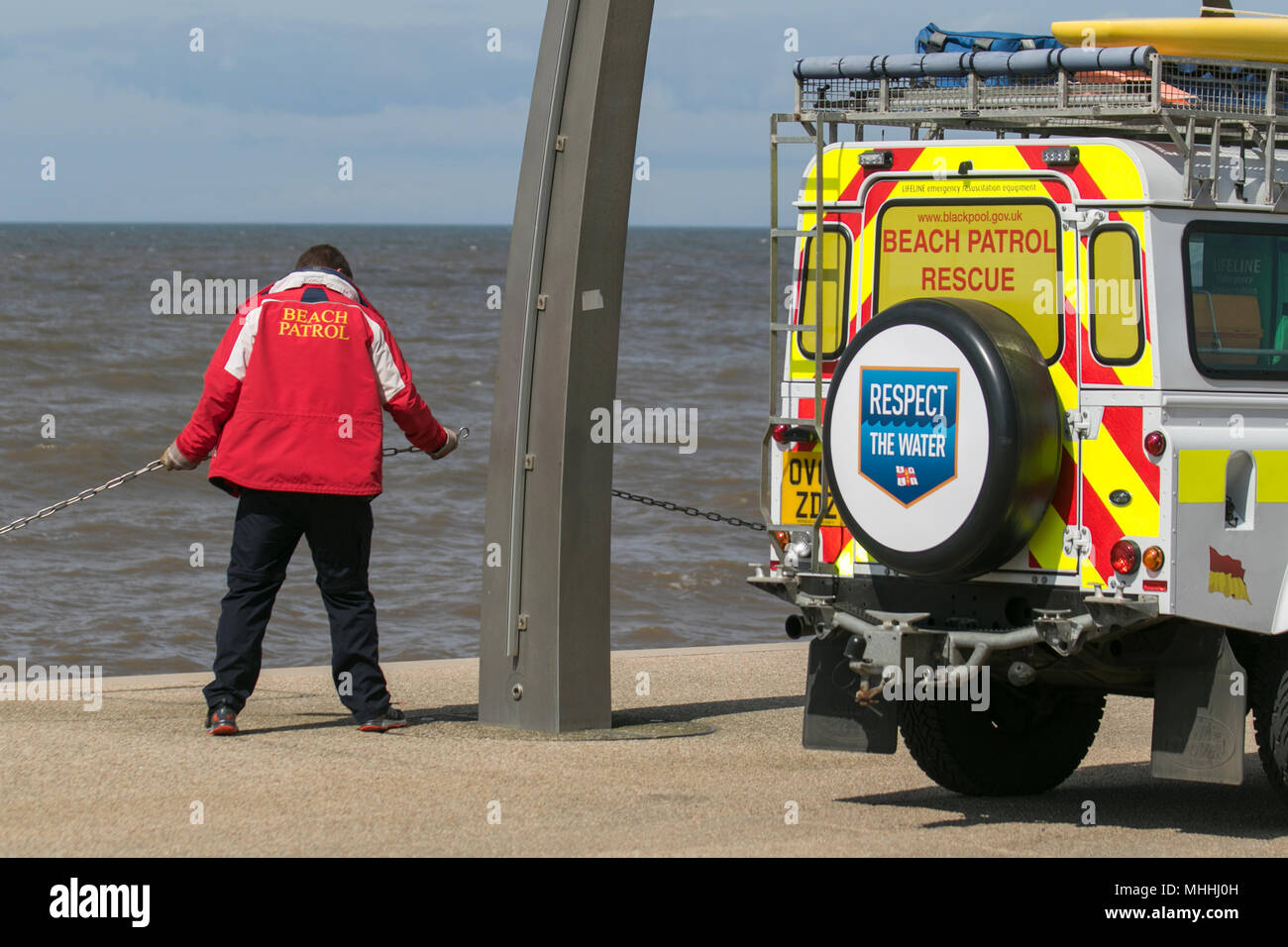 Beach patrol rescue Land Rover vehicle with man securing seaside ...