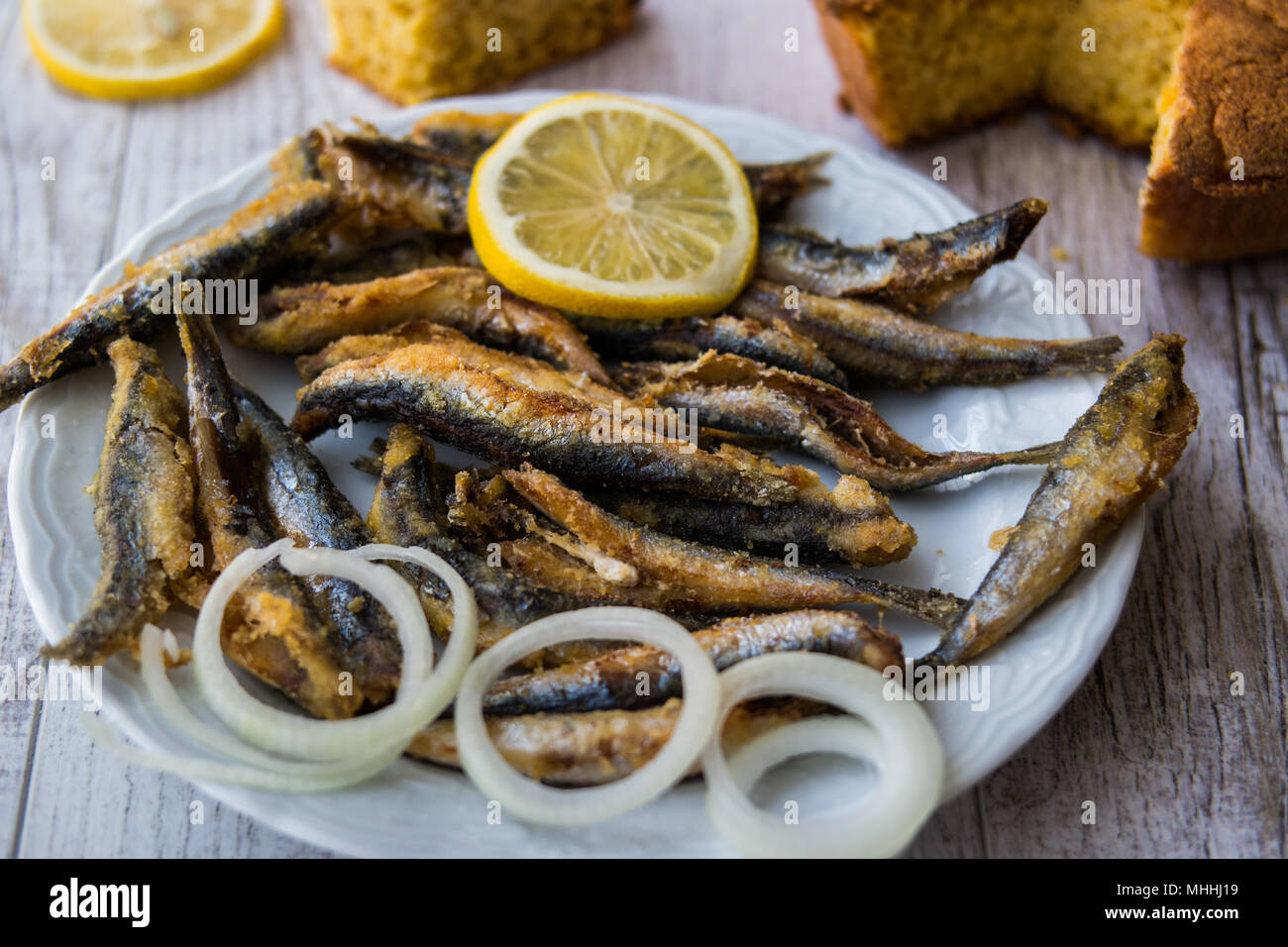 Turkish Hamsi Tava with cornbread / Fried Anchovies on a white wooden ...