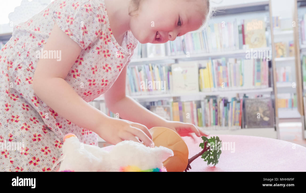 Little girl playing in kids section of public library Stock Photo - Alamy