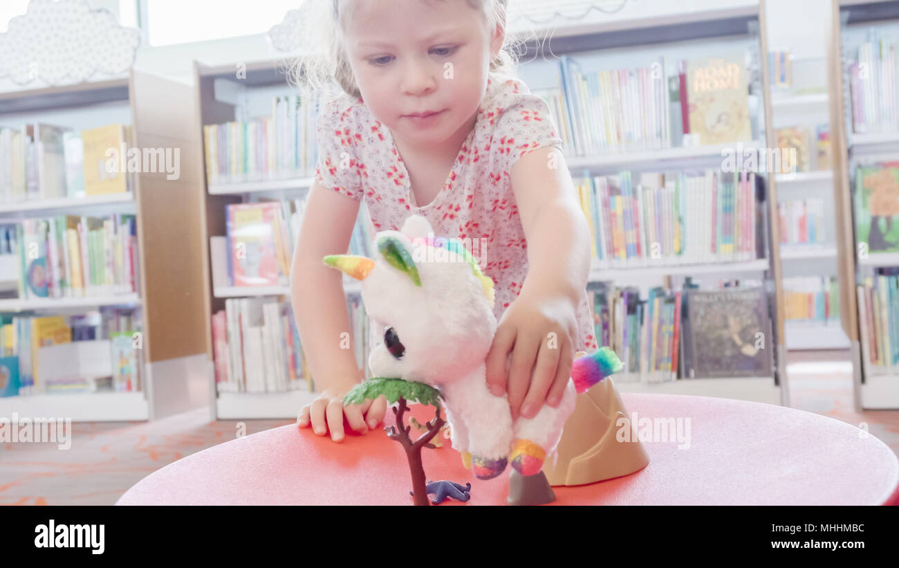 Little girl playing in kids section of public library Stock Photo - Alamy