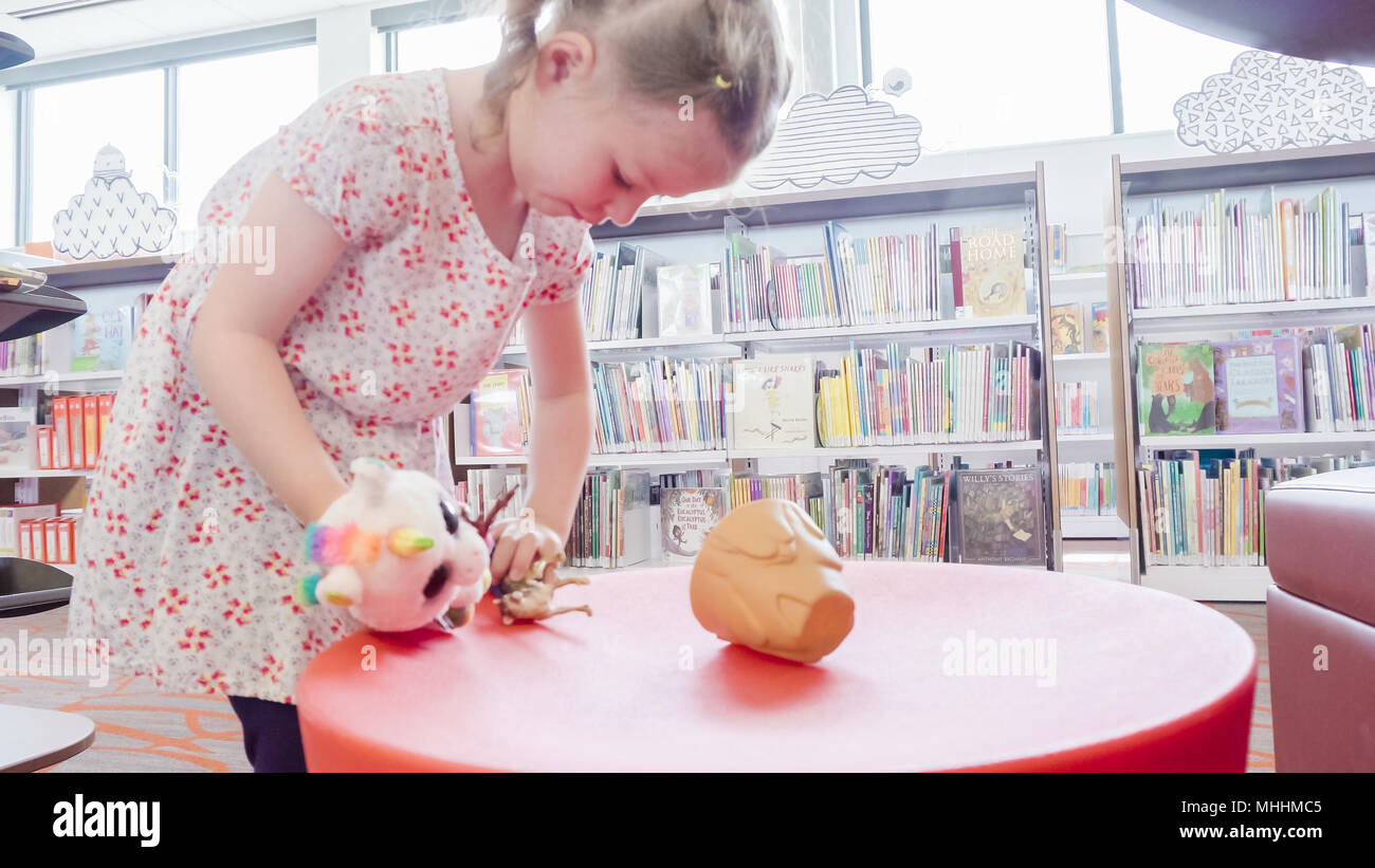 Little girl playing in kids section of public library Stock Photo - Alamy
