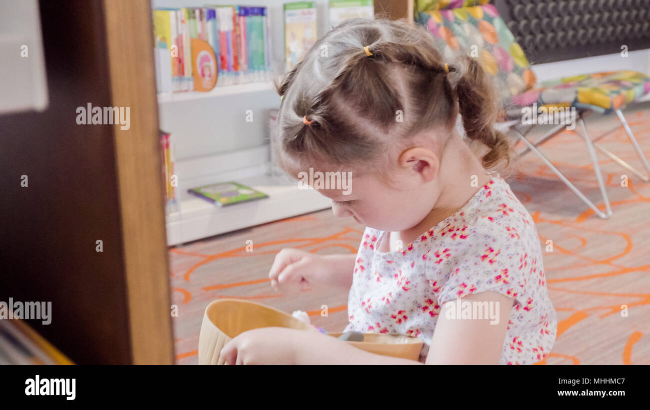 Little girl playing in kids section of public library Stock Photo - Alamy