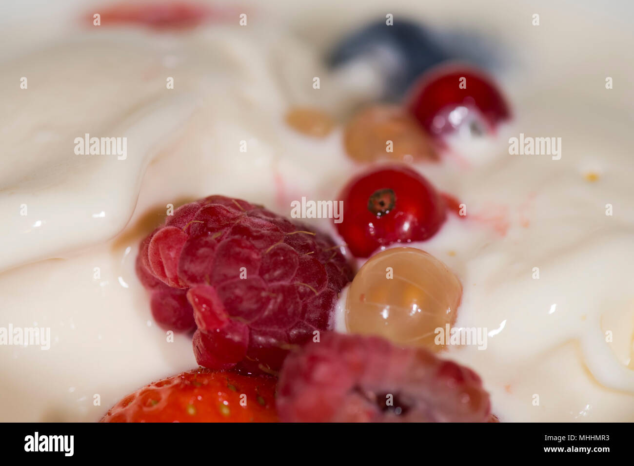 Red raspberry and strawberry on ice cream background Stock Photo - Alamy