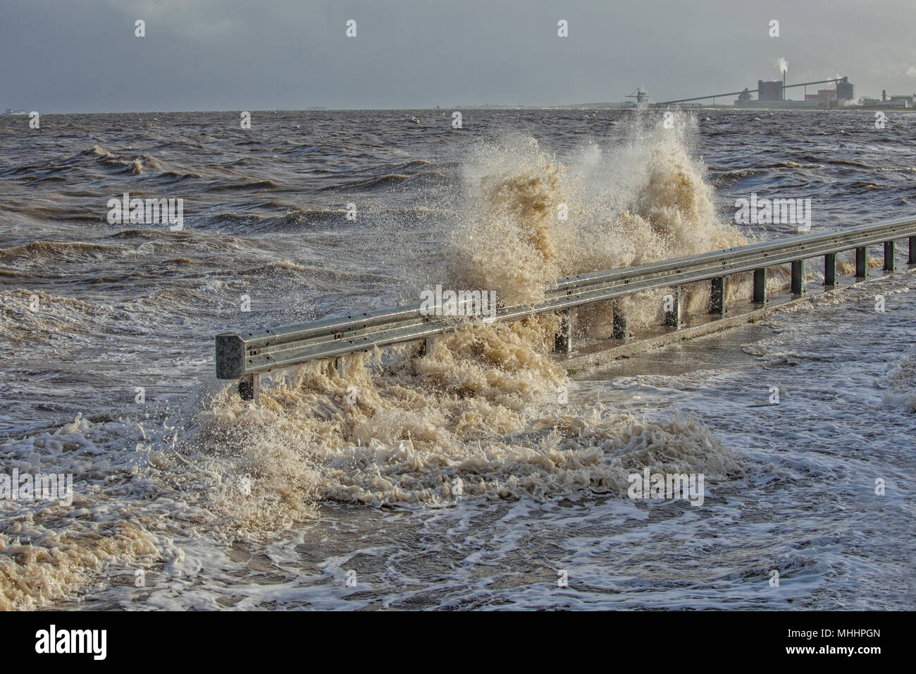 Waves of ocean water splashing on a Dutch dike after heavy rains and ...