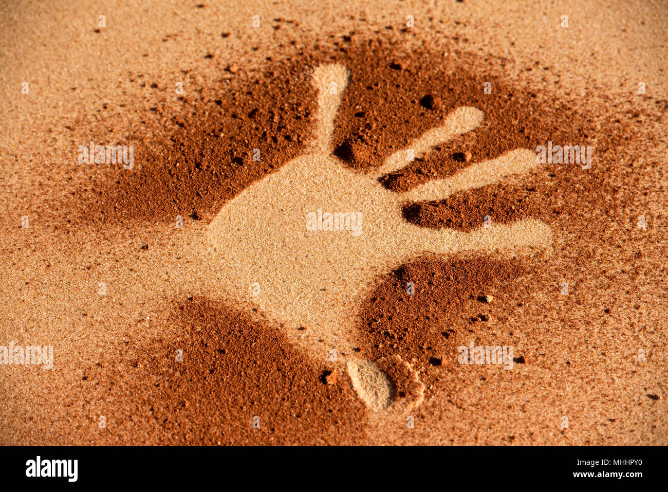 Red australian soil hand shape on sandy beach Stock Photo - Alamy