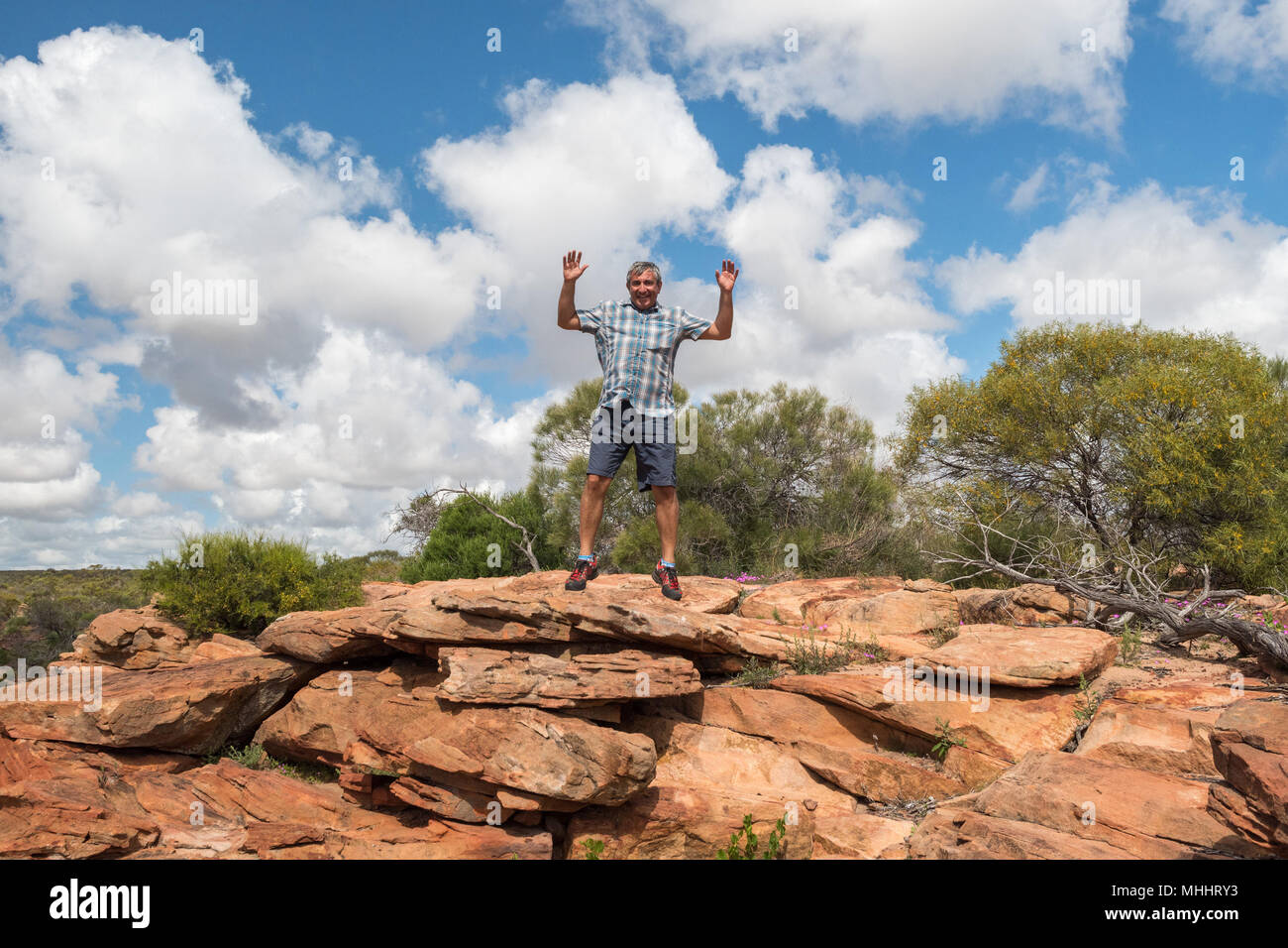man jumping from red cliff in Australia Stock Photo - Alamy