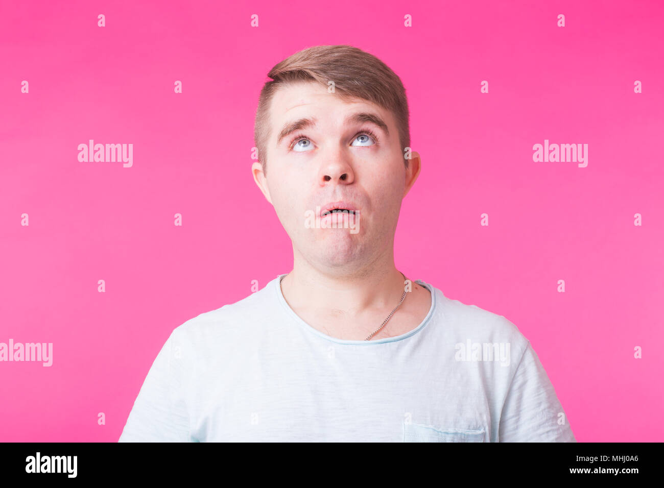 portrait of young bored man looking up on pink background Stock Photo ...