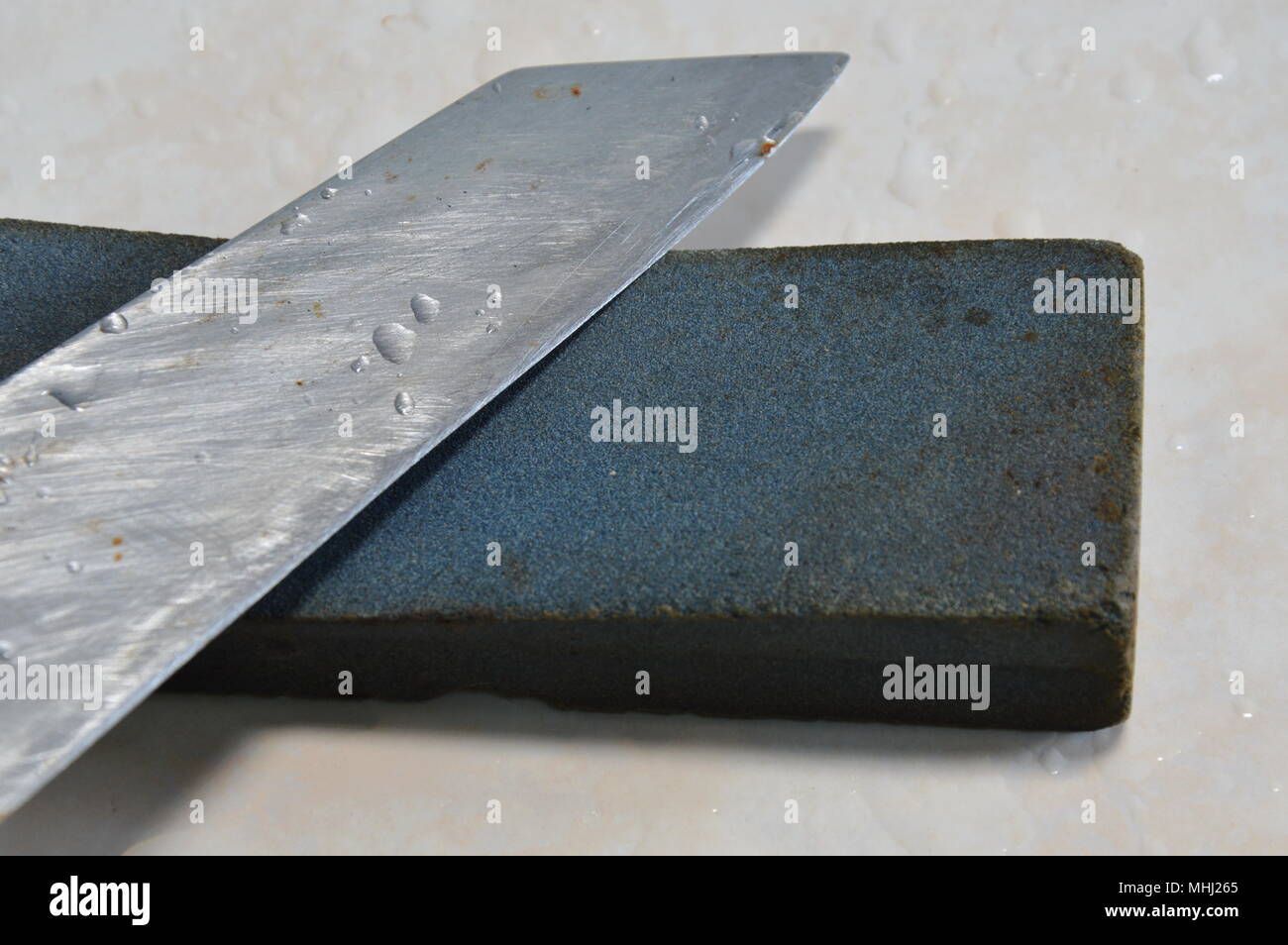 kitchen knife and grindstone on tile floor Stock Photo - Alamy