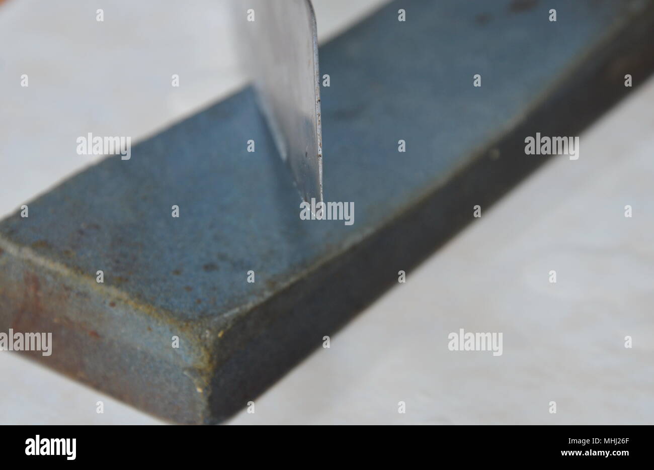 kitchen knife and grindstone on tile floor Stock Photo - Alamy