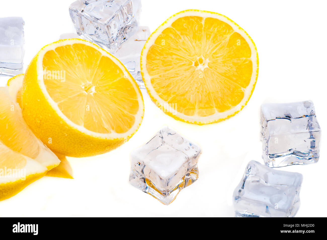 Cubes of cold ice, and halves of fresh, bright juicy lemon on a white ...