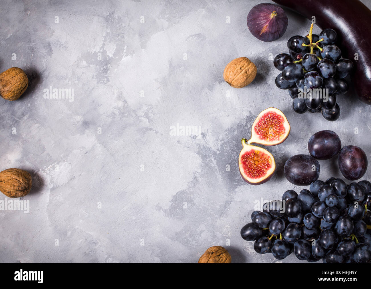 Fresh organic raw purple colored vegetables and fruits on stone ...