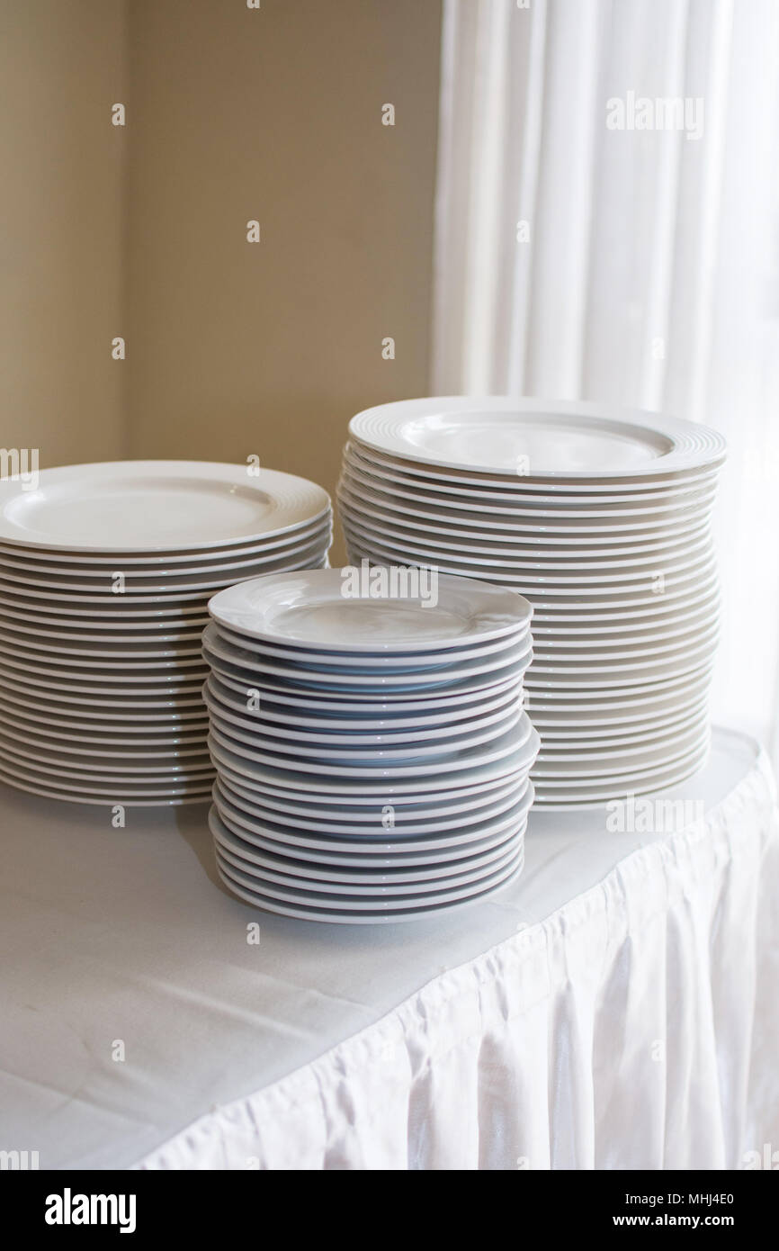 Group of white plates stacked together in a hotel Stock Photo - Alamy