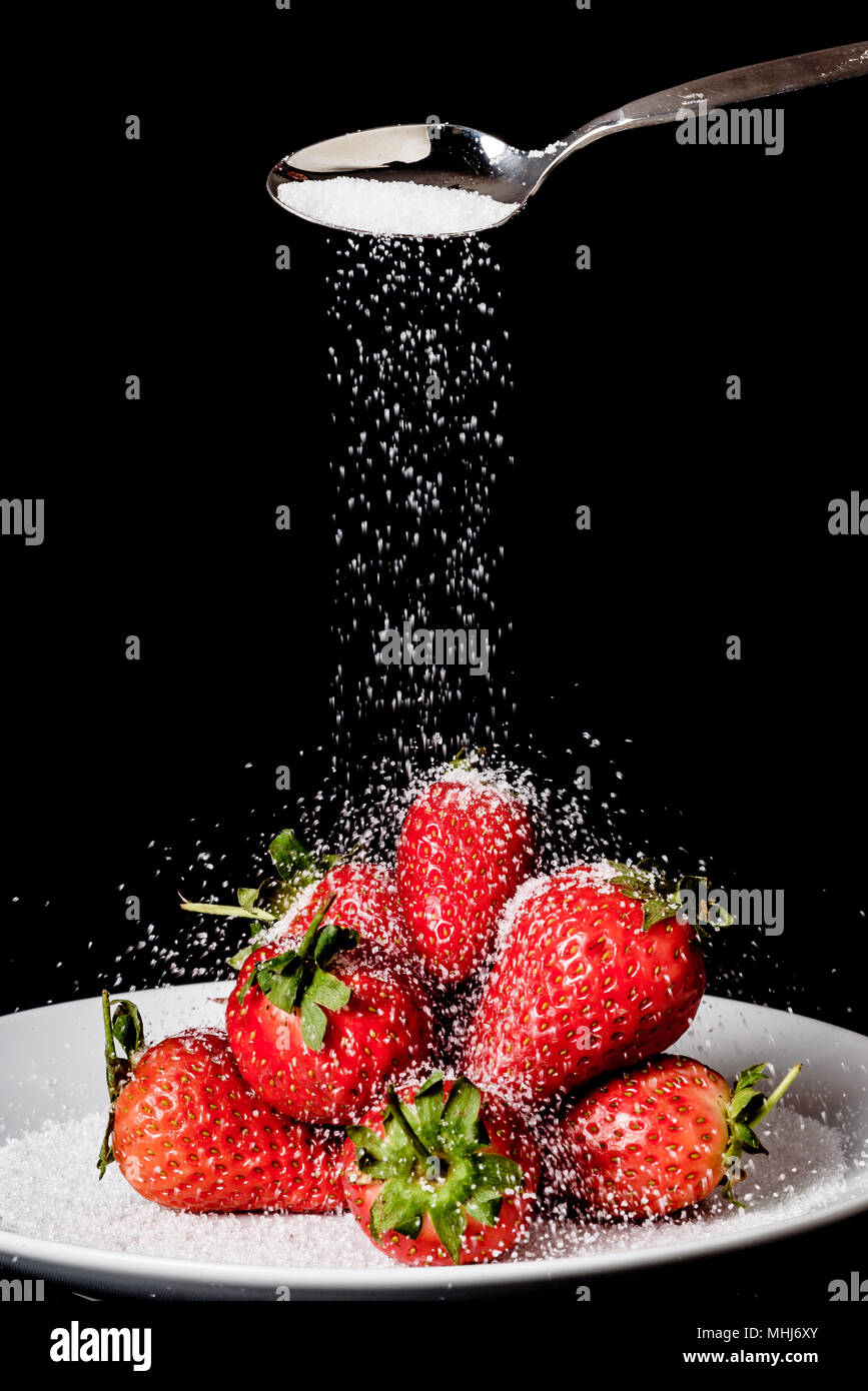 Sprinkling sugar over strawberries hi-res stock photography and images ...