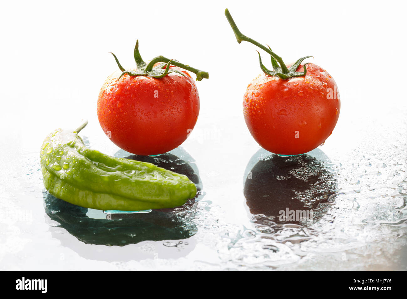 Two fresh tomatoes and their reflections on a white background Stock ...