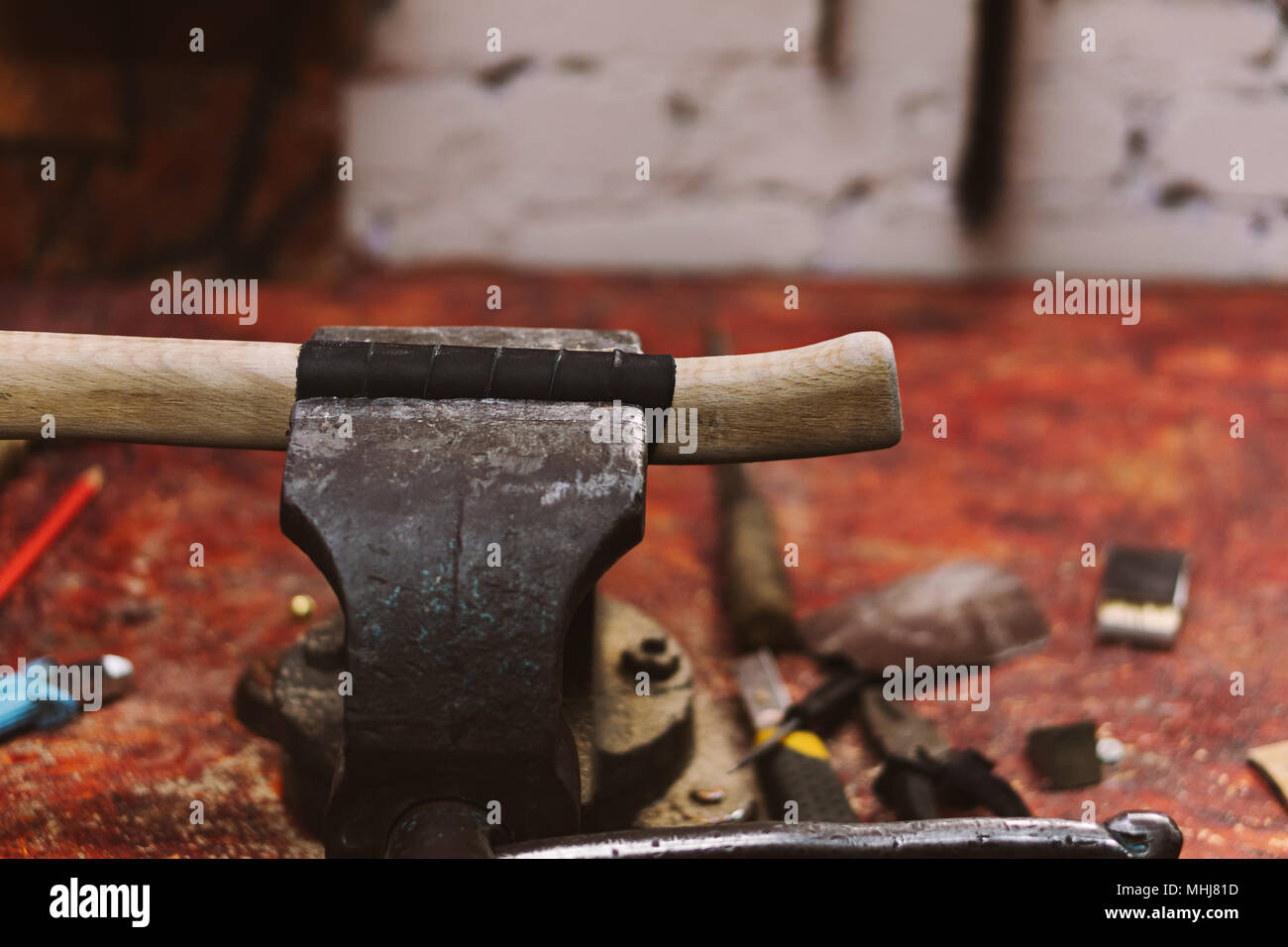 Wooden handle with leather winding is fixed in vice in carpentry ...