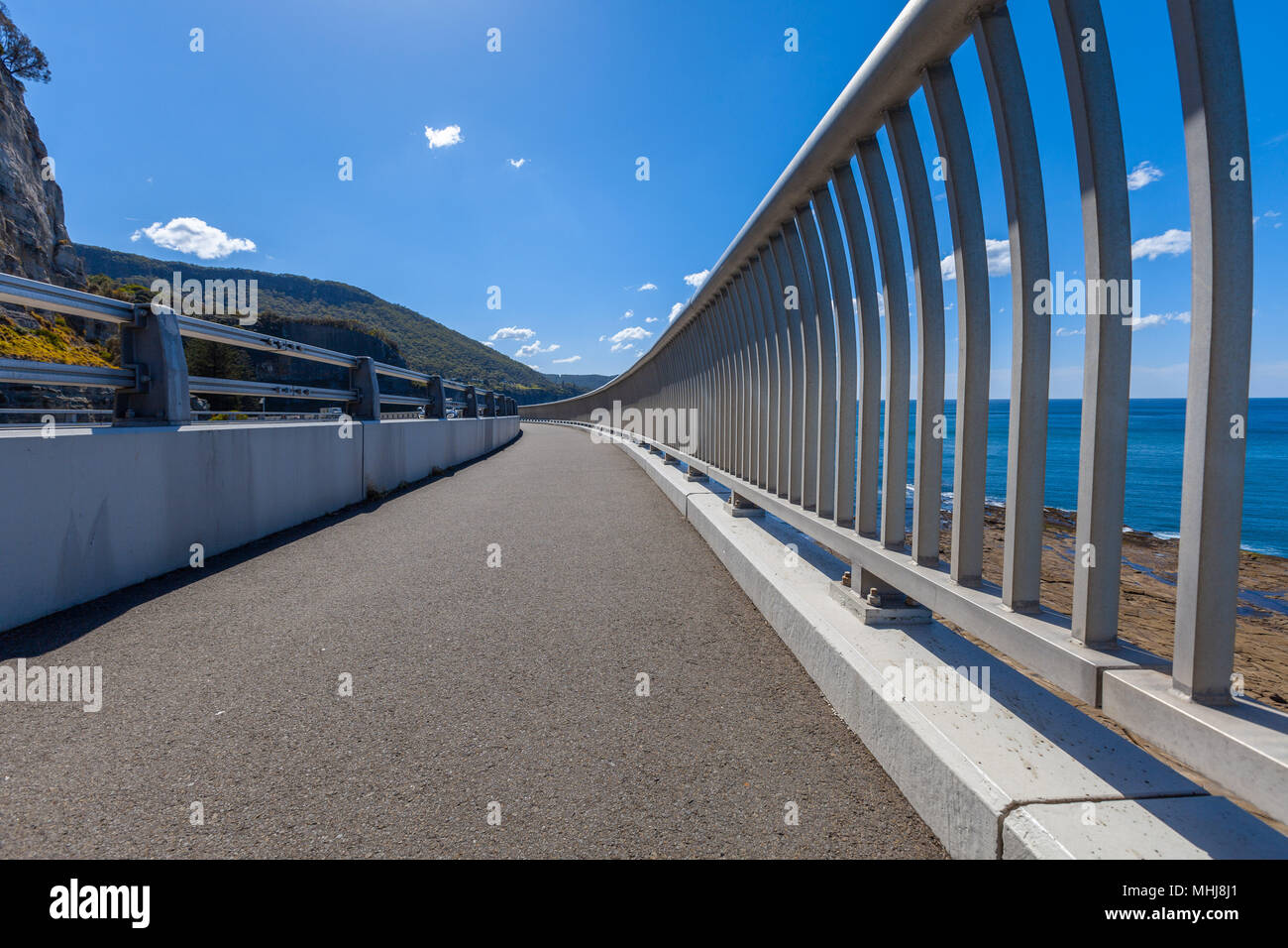 Walking path along the Sea Cliff Bridge on Grand Pacific Drive in ...