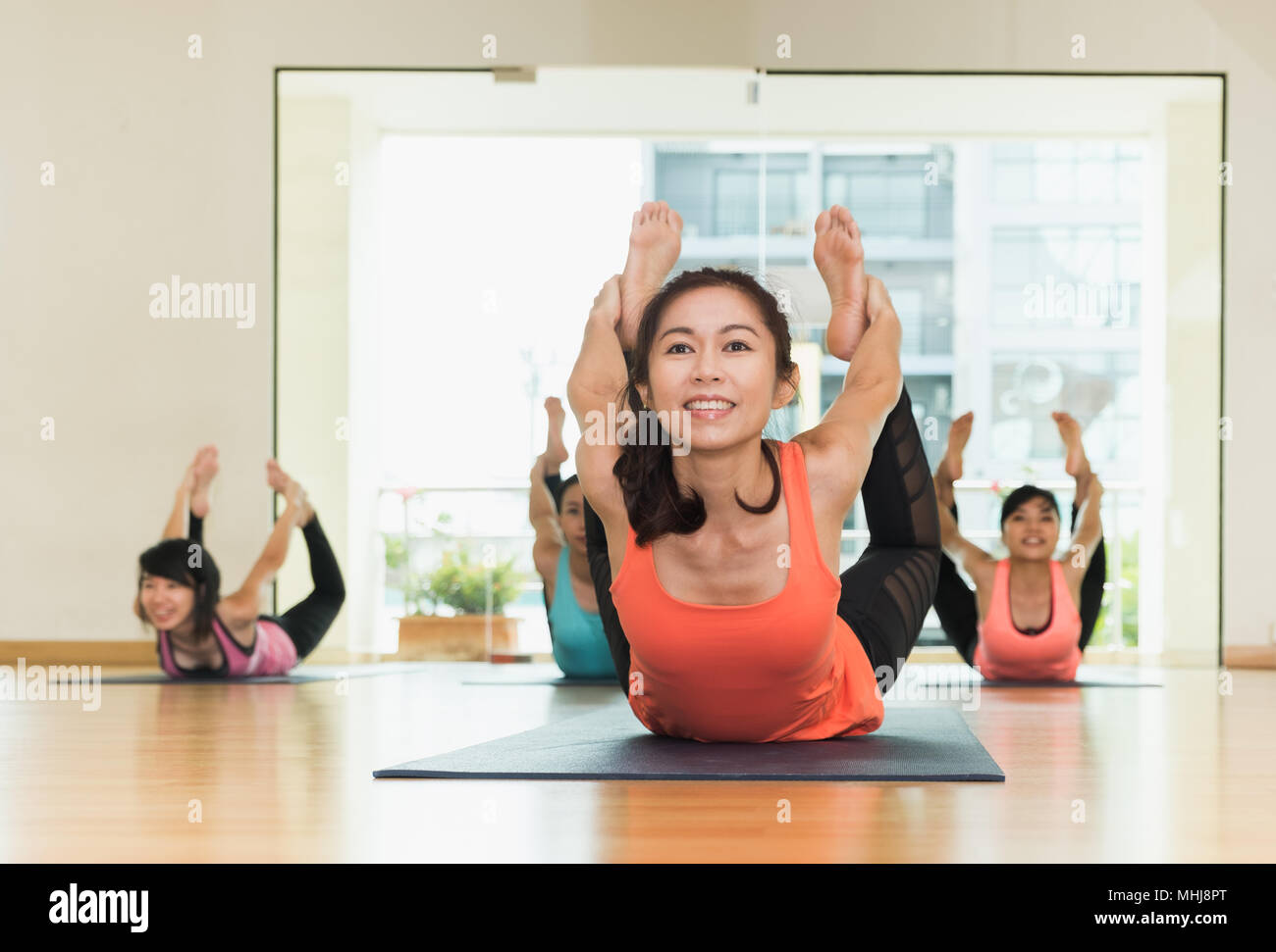 Yoga class in studio room,Group of people doing bow poses,stretching ...