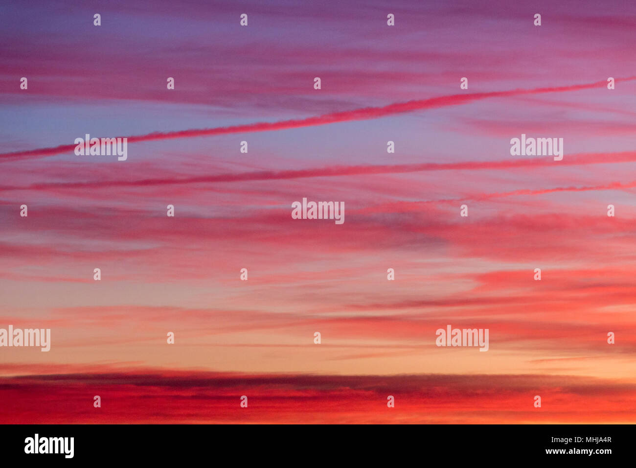 Clouds and jet vapor trails creating beautiful, colorful texture in the ...