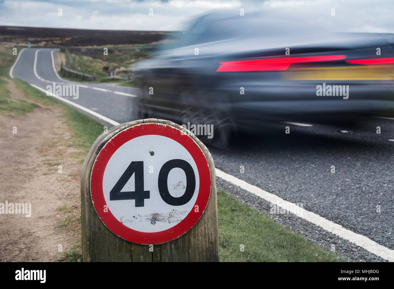Speed limit sign on rural road with car Stock Photo - Alamy