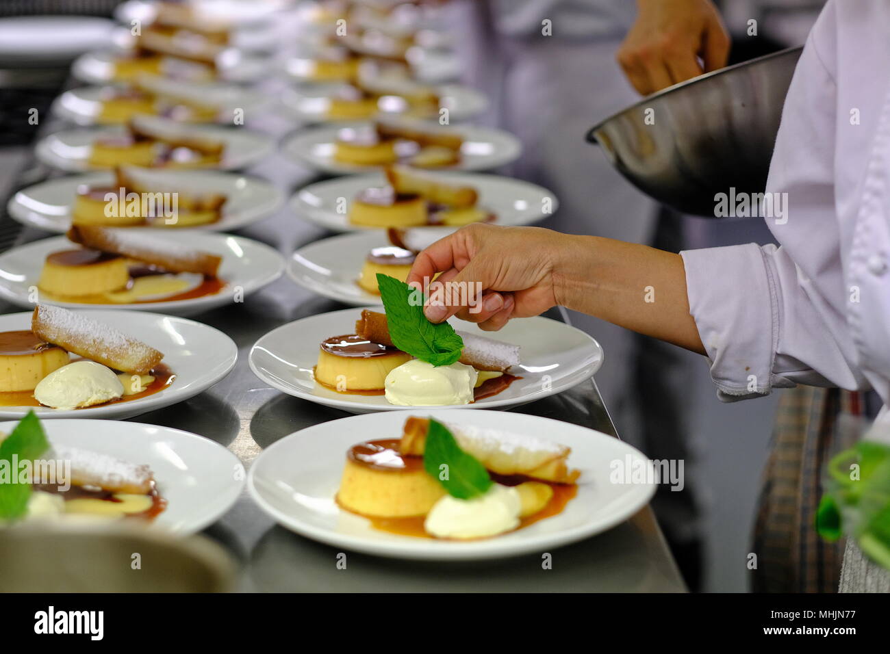 student preparing meals for their graduation guests at a cooking school ...