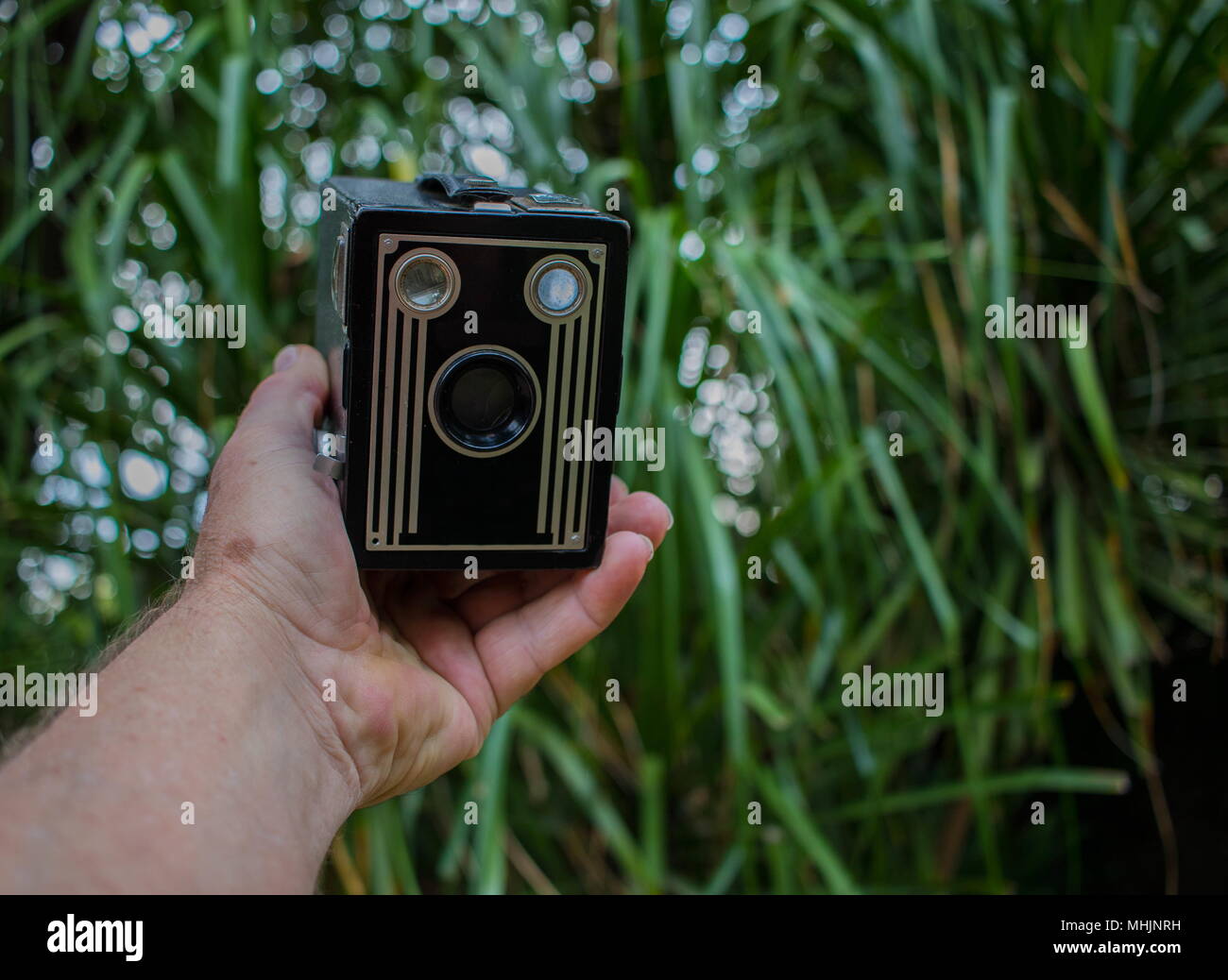 Hand holding a classic box camera like in taking a modern day selfie ...