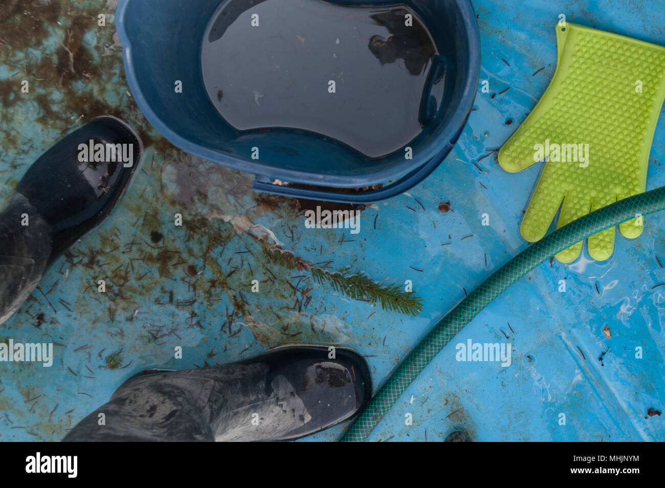Overhead shot of a dirty swimming pool bottom with rubber boots and ...