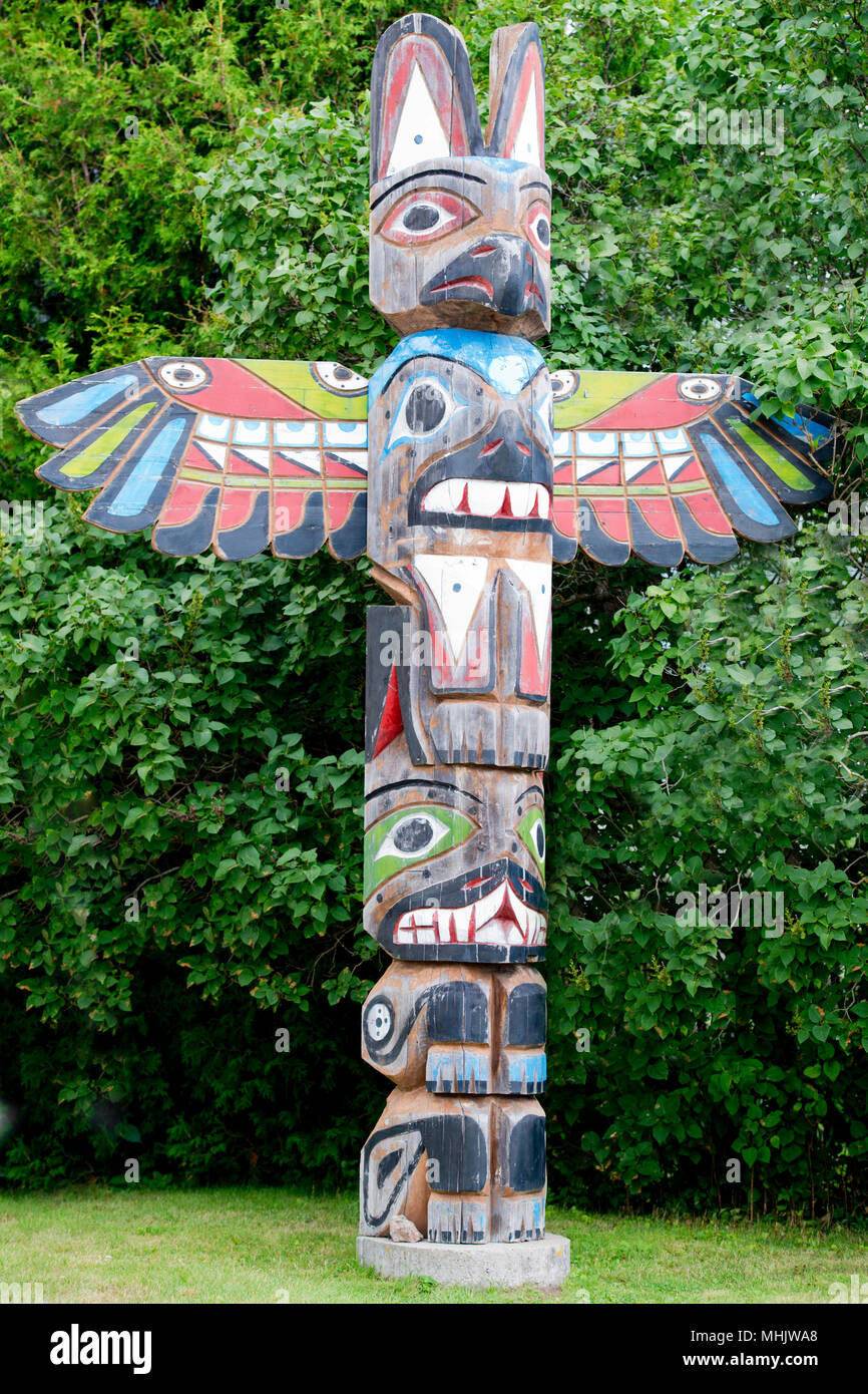 Isolated totem wood pole in the green forest background Stock Photo - Alamy
