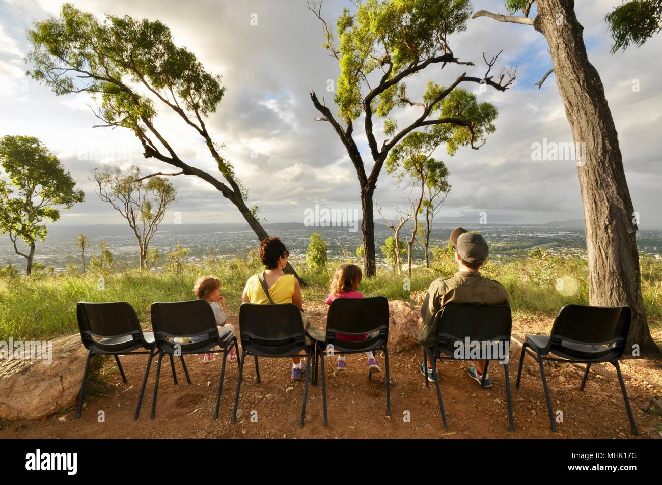A family sitting on cheap black chairs looking at the scenery in a ...