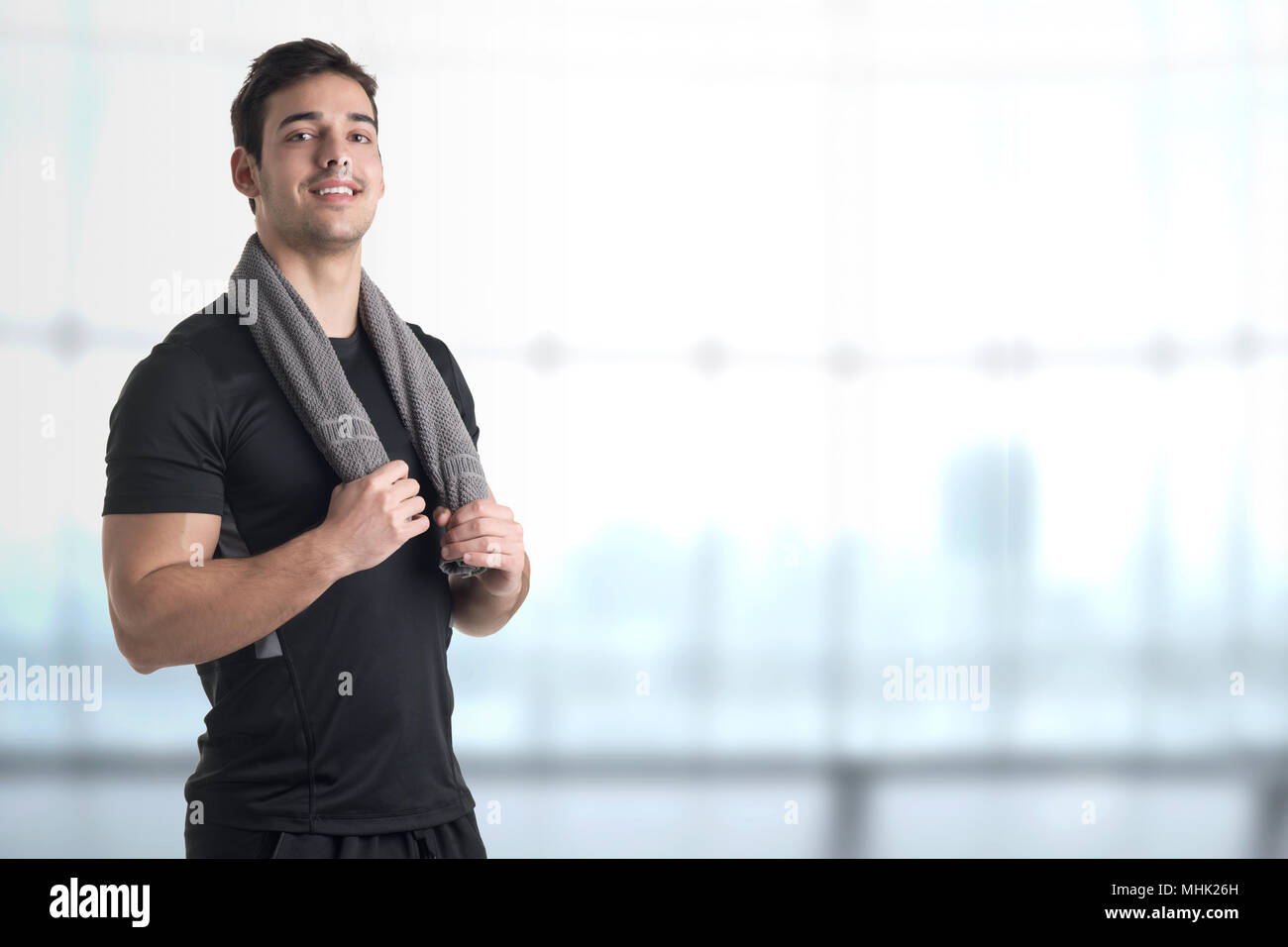 Fit man with a towel around his neck, in a gym Stock Photo - Alamy