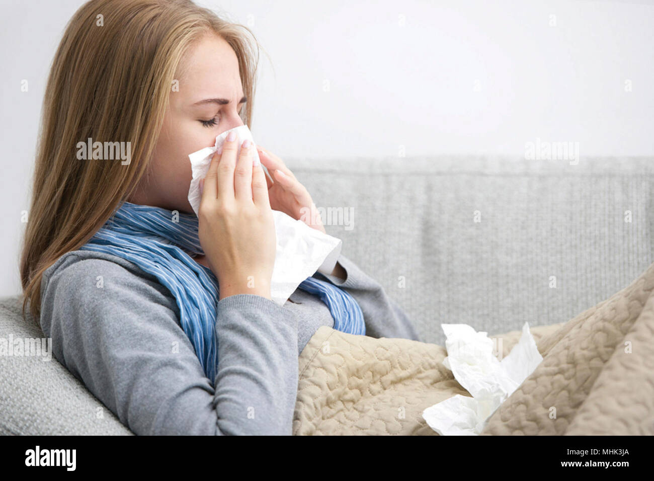 Teenage girl with flu blowing nose Stock Photo - Alamy