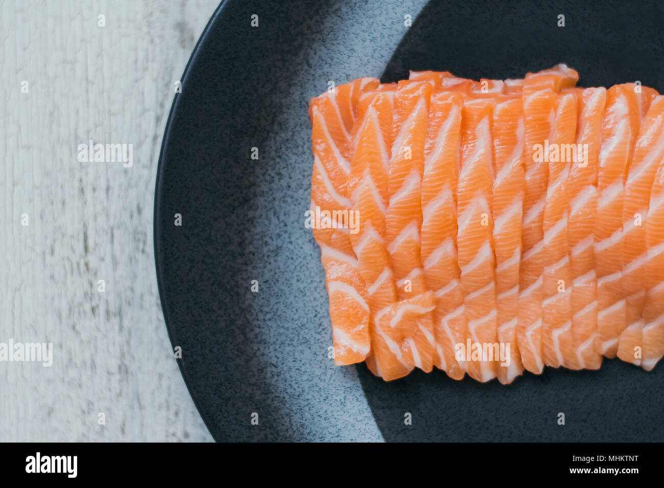 Salmon sashimi on black ceramic plate Stock Photo - Alamy