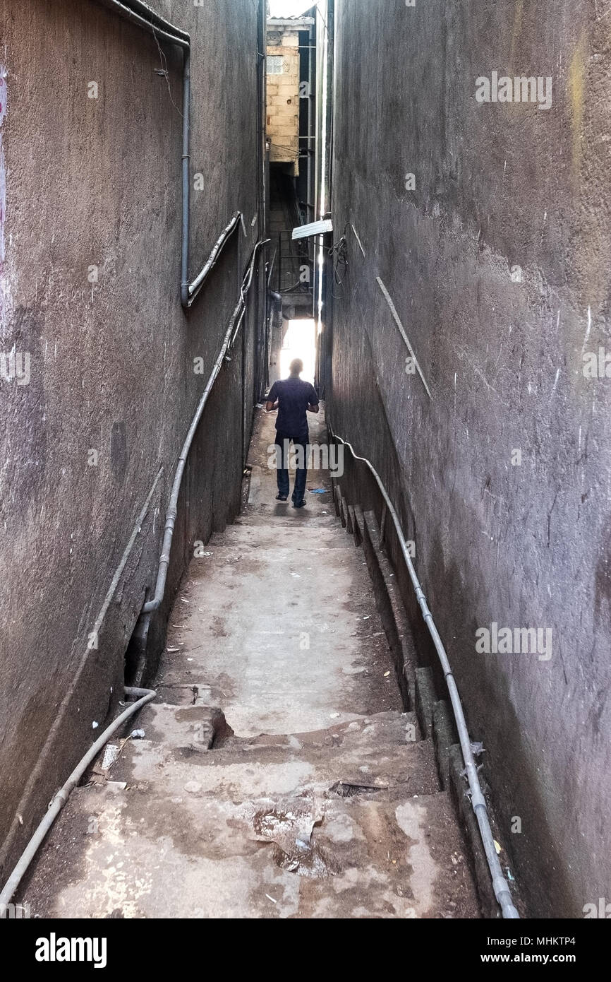Silhouette of man going away between walls of buildings Stock Photo - Alamy